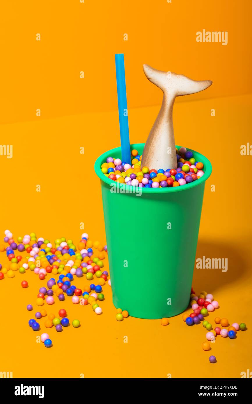 Gray dolphin figurine placed in green bucket with multicolored bright ...