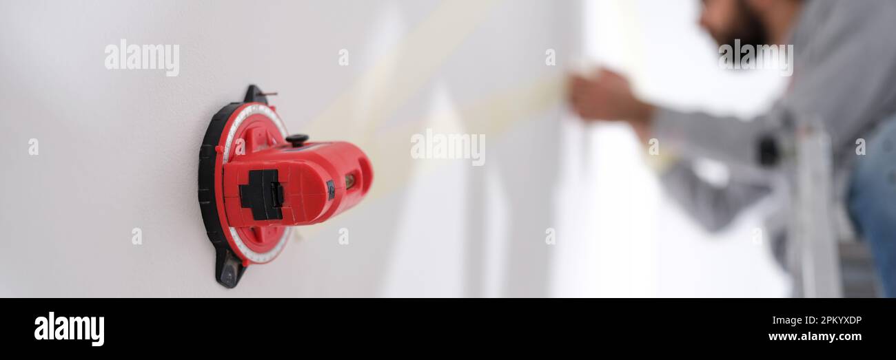 Builder using professional measuring device for marks Stock Photo - Alamy