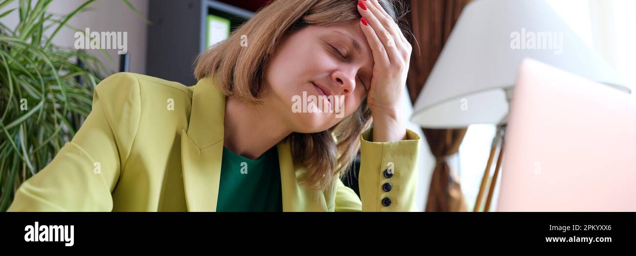 Tired businesslady putting hand to forehead and closed eyes Stock Photo ...