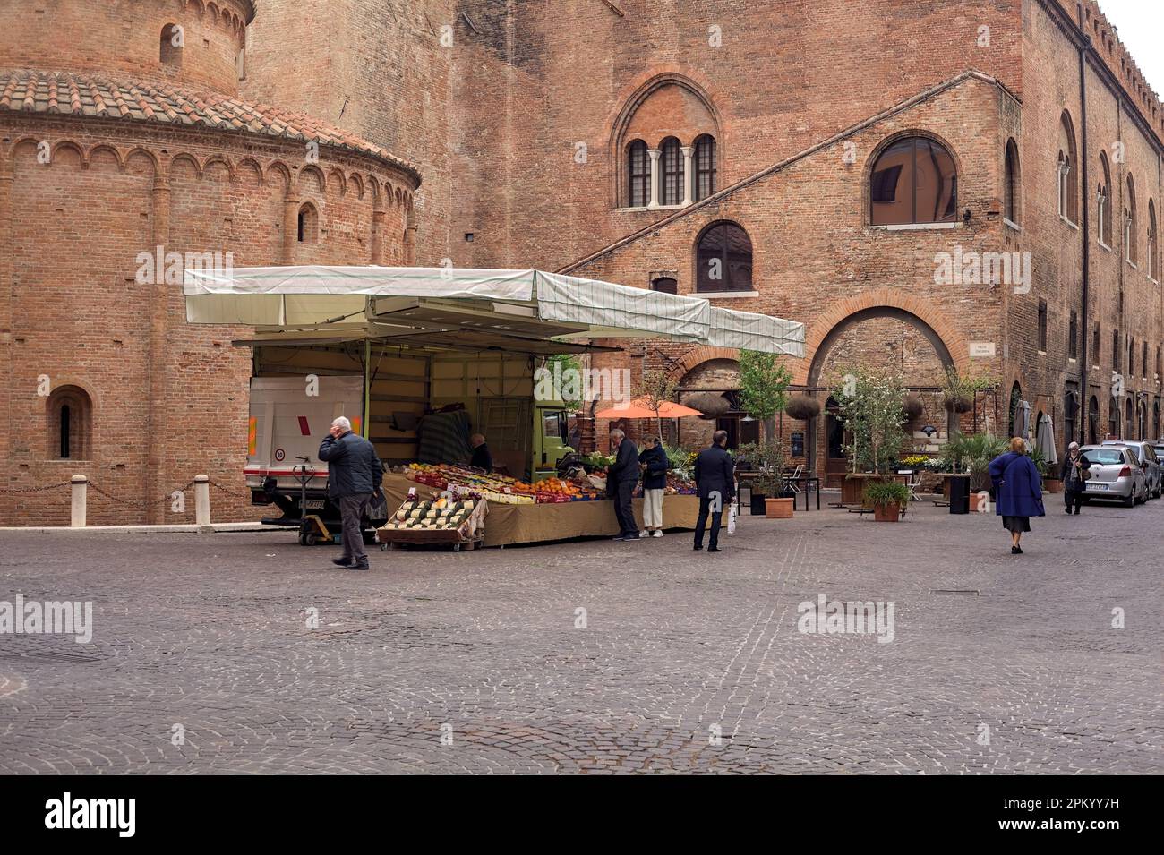 Grocery stall in a square behind historical buildings in a town on a ...