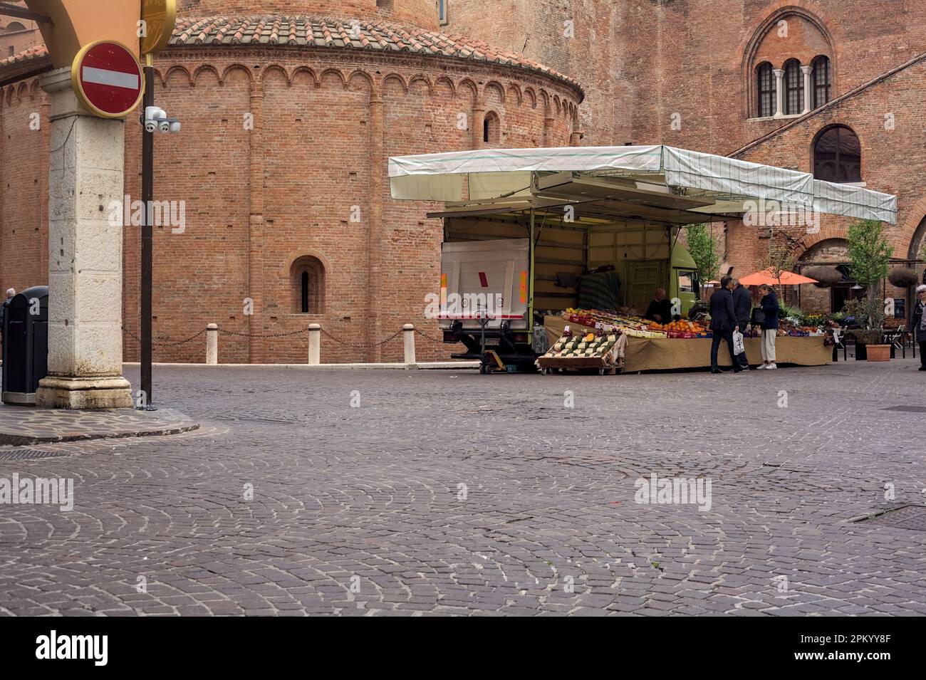 Grocery stall in a square behind historical buildings in a town on a ...