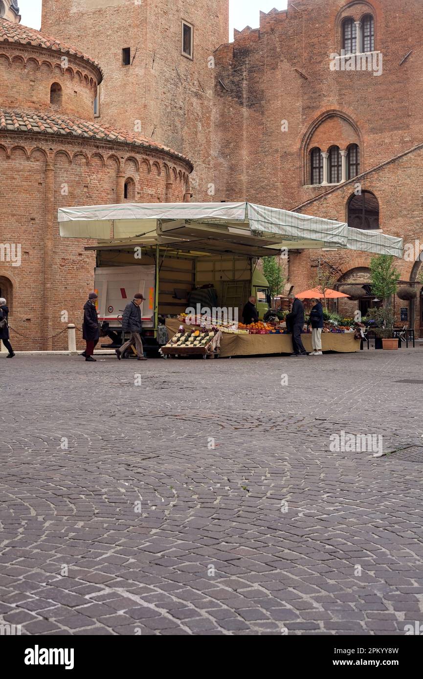 Grocery stall in a square behind historical buildings in a town on a ...