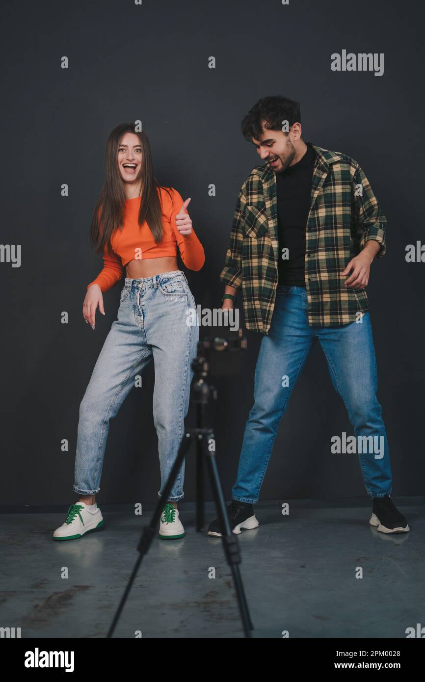 Happy active young couple recording on smartphone their dance challenge ...