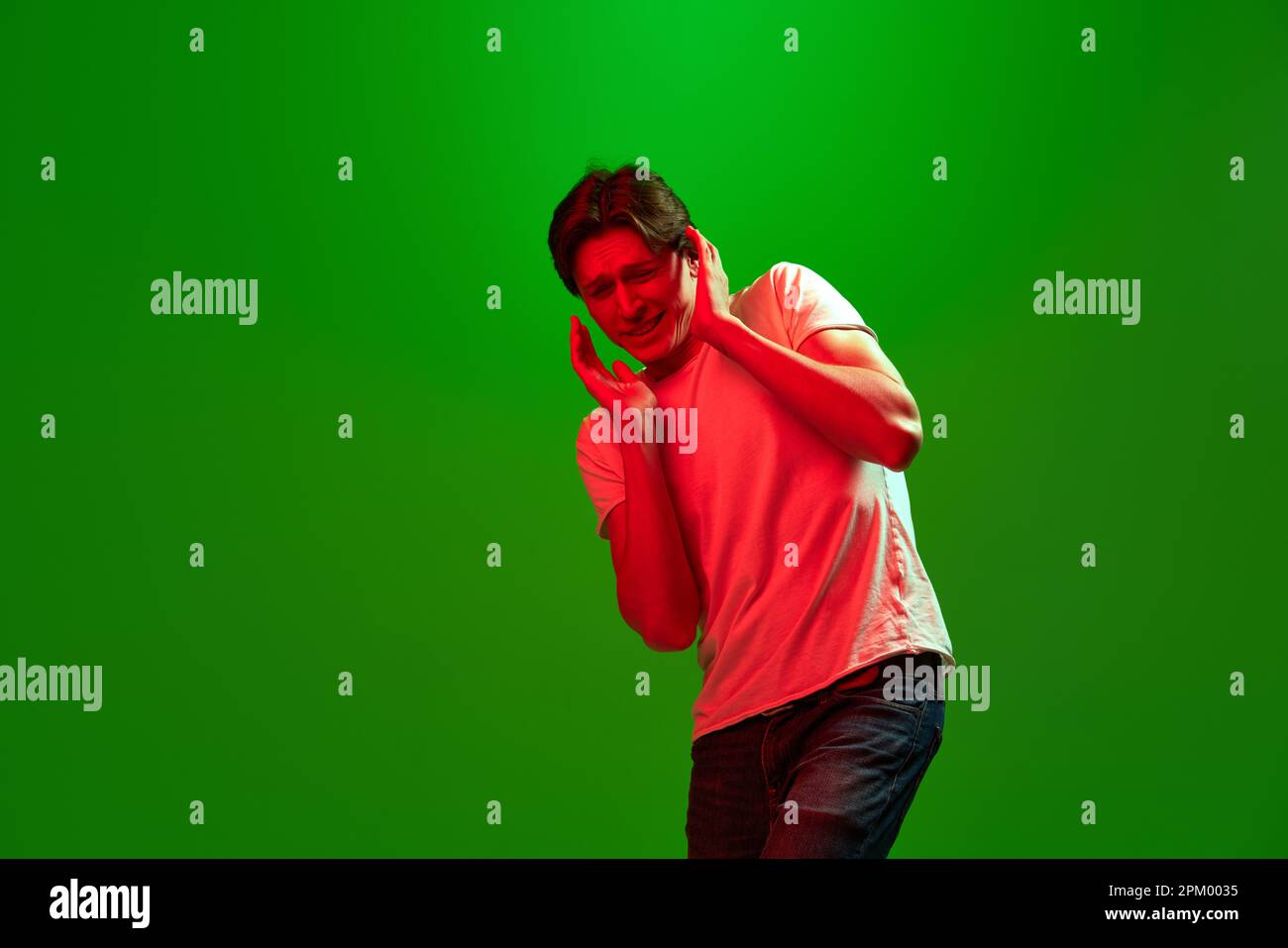 Portrait of young guy, man wearing shirt standing with uncertain facial ...