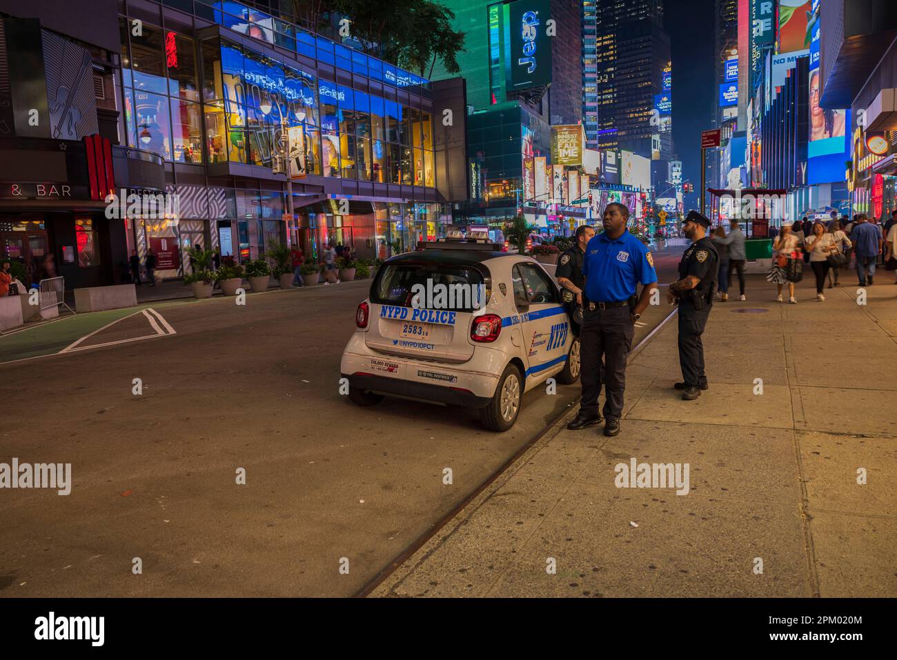 View of policemen near police car on Manhattan street at night time ...