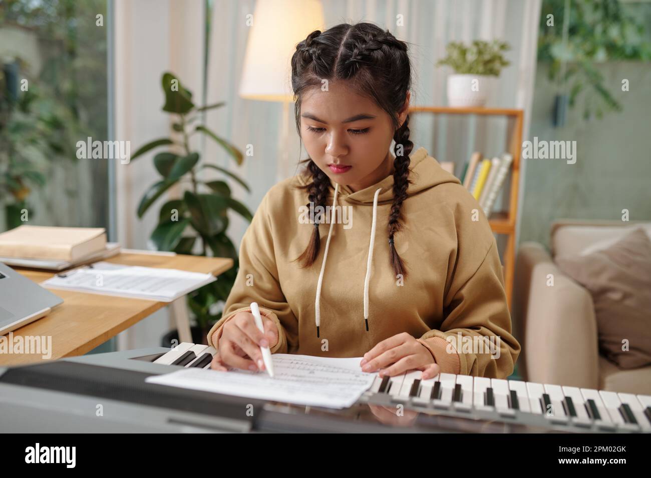 Serious girl reading music notes when doing homework for music class ...