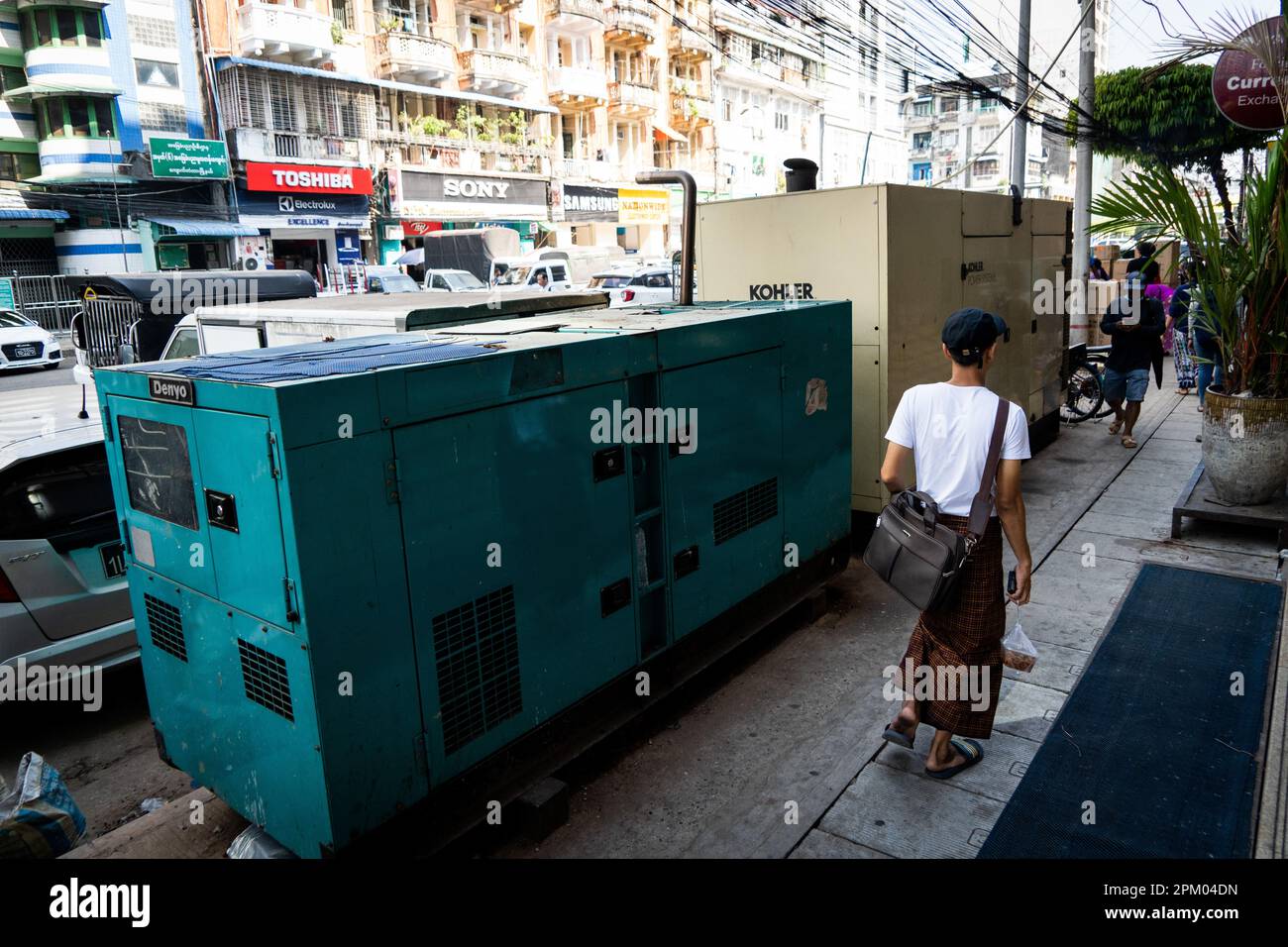 Yangon, Myanmar. 10th Apr, 2023. Someone walks past large generators on ...
