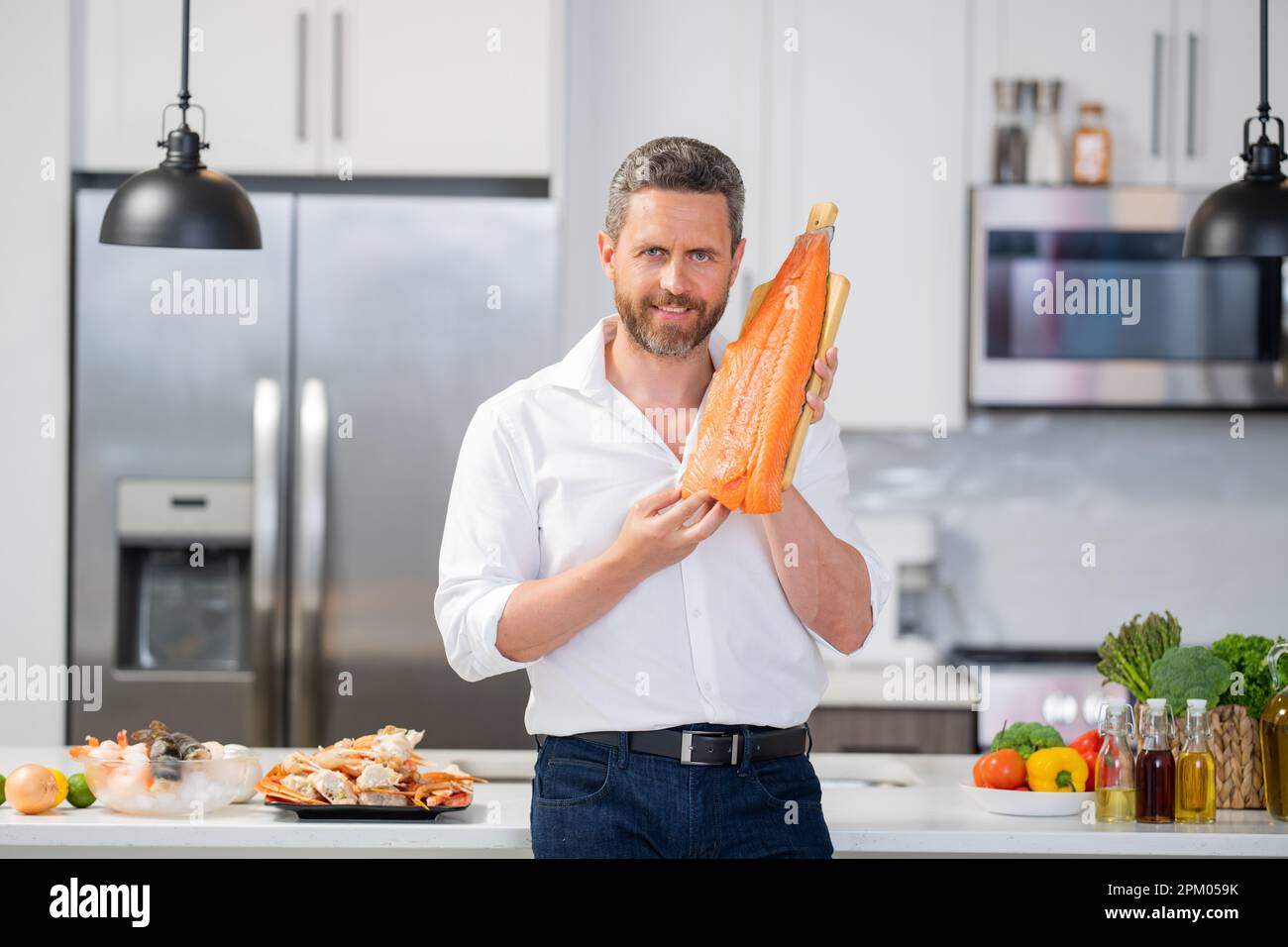 Chef man cooking seafood crab and shrimp, salmon and lobster in kitchen ...