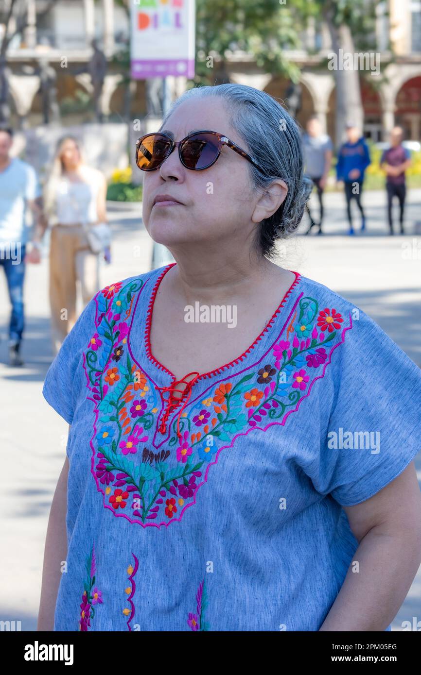 Portrait of Mexican woman with serious expression looking up, against ...