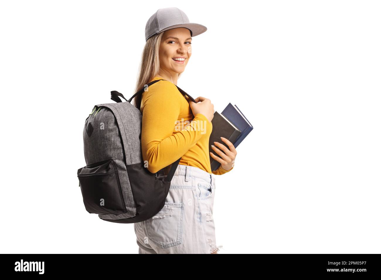 Female student with a backpack looking over shoulder and holding books ...