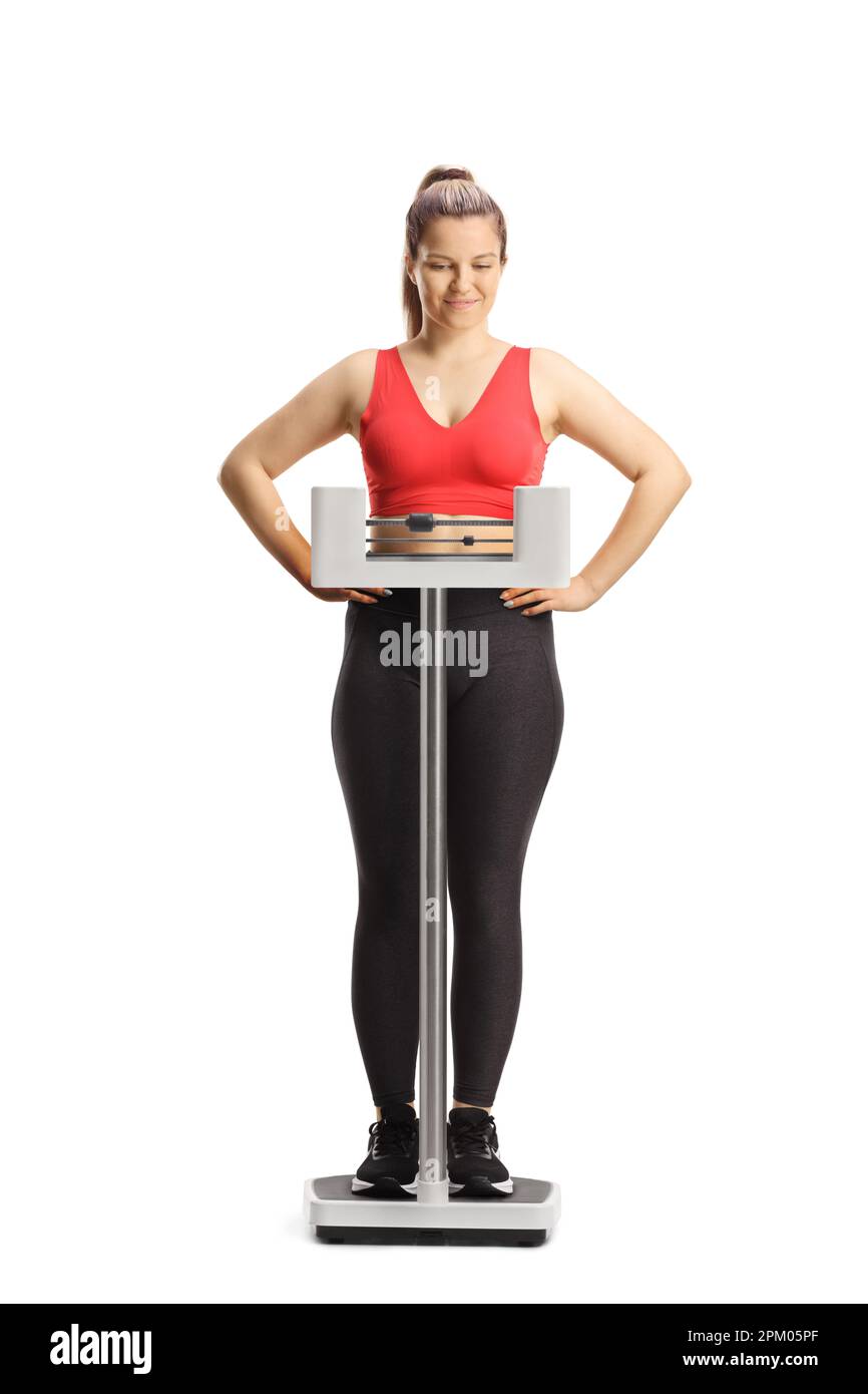 Young woman in sportswear weighing on a medical scale and smiling ...