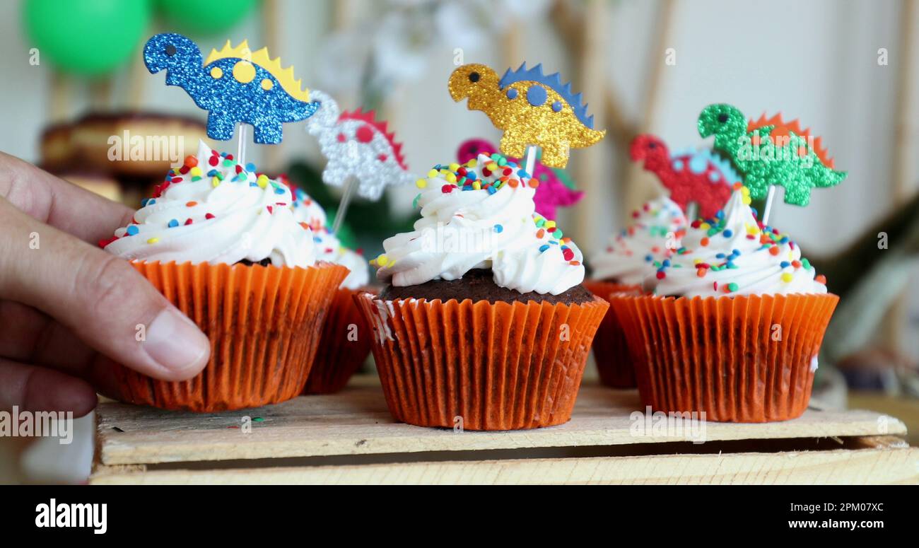 Placing cupcake at birthday party decor table Stock Photo - Alamy