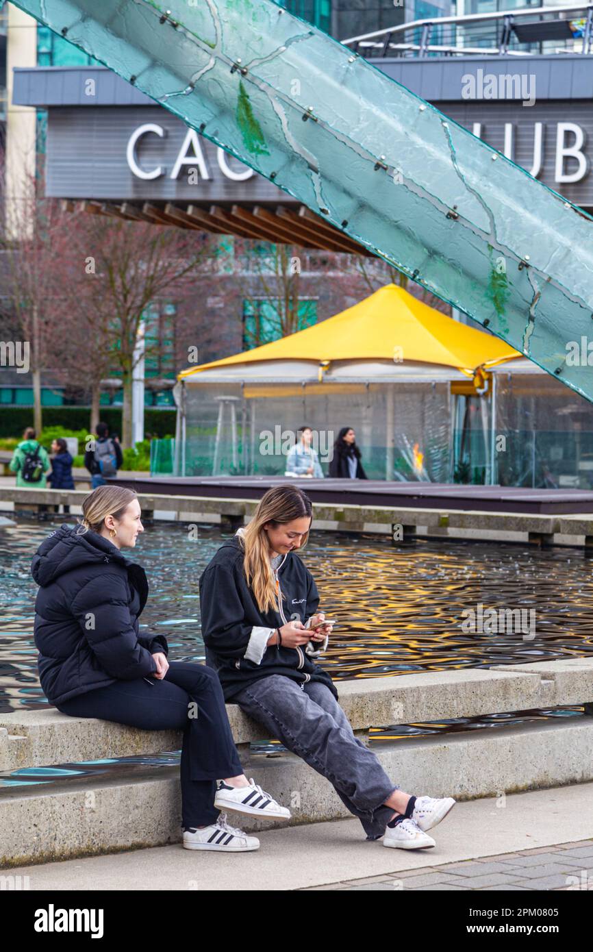 Two friends sitting by the Olympic Cauldron in Jack Poole Plaza ...