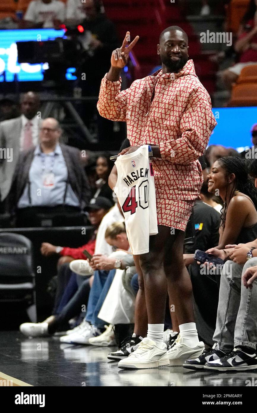 Former Miami Heat player Dwyane Wade holds a Udonis Haslem jersey as he ...