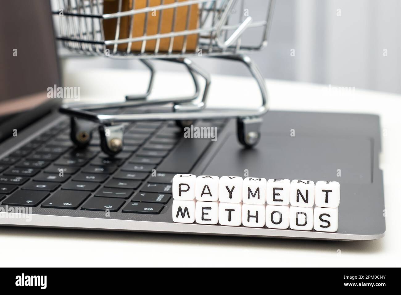 Payment methods words on cubes with a toy shopping cart and cardboard ...