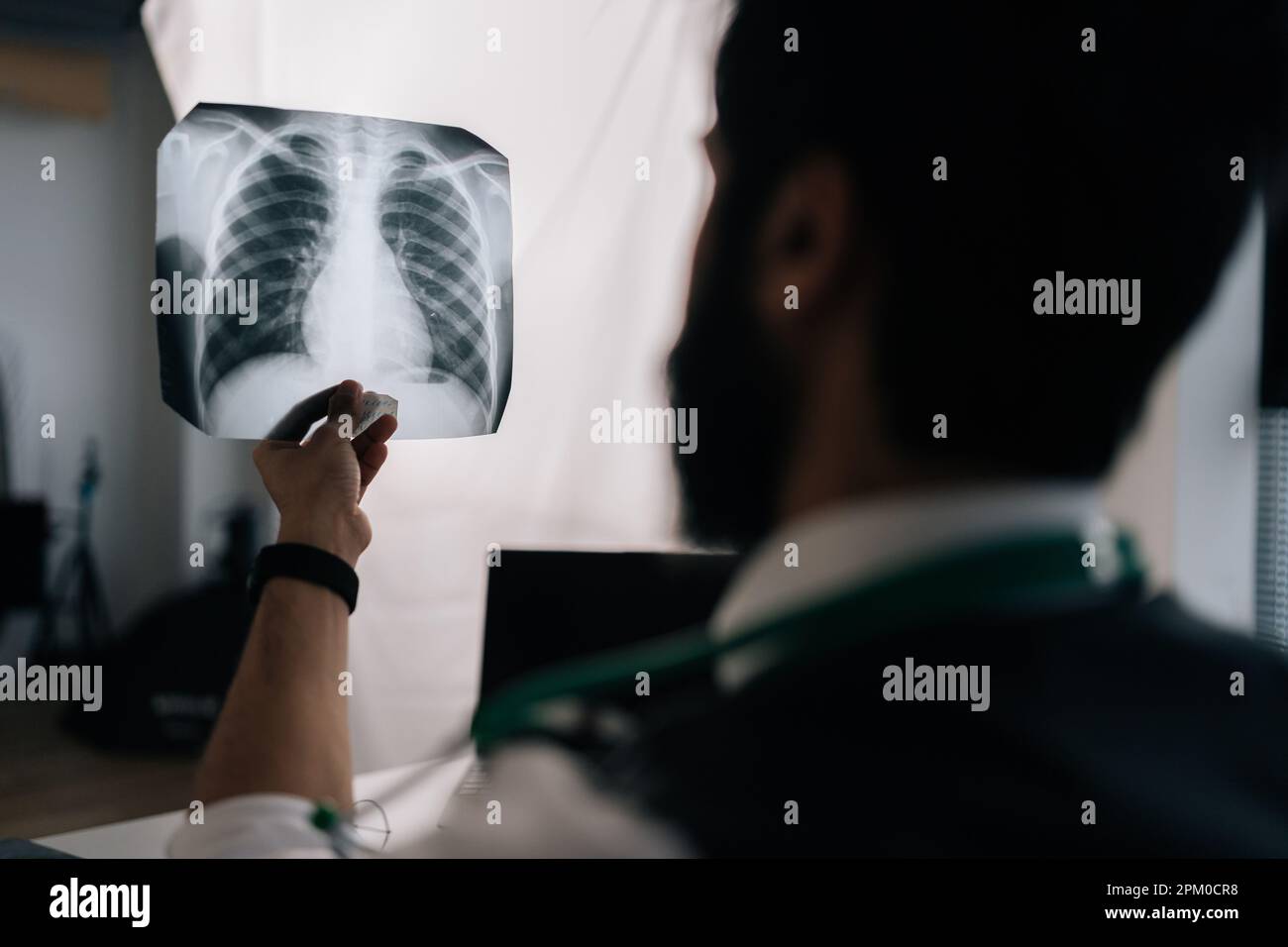 Closeup back view of unrecognizable male doctor examining patient chest ...