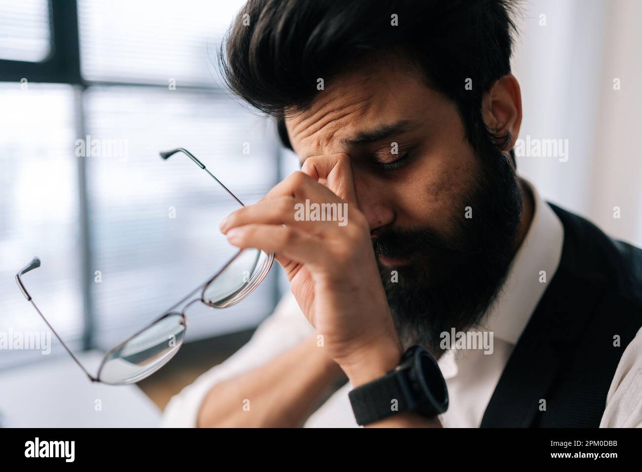 Closeup face of tired exhausted Indian businessman massaging nose ...