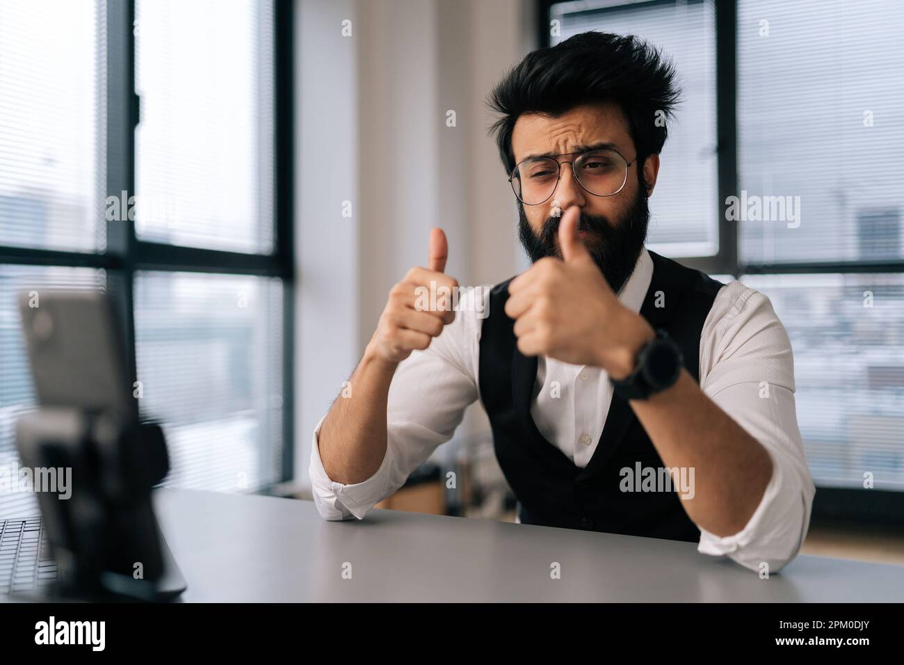 Confident Indian male vlogger showing thumb up gesture talking to ...