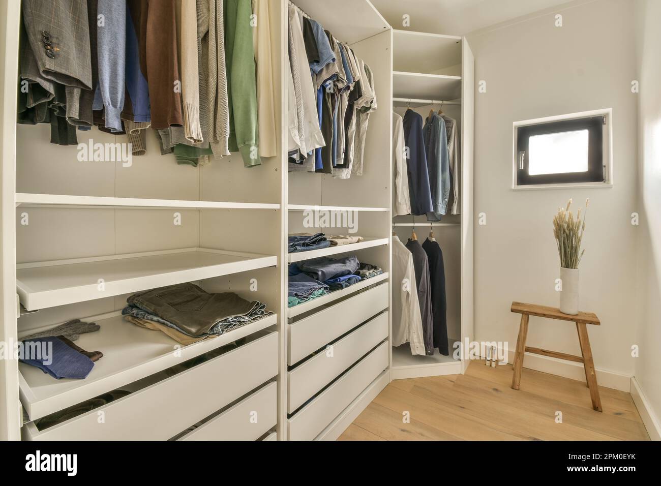 the inside of a walk - in closet with clothes hanging on shelves, and ...