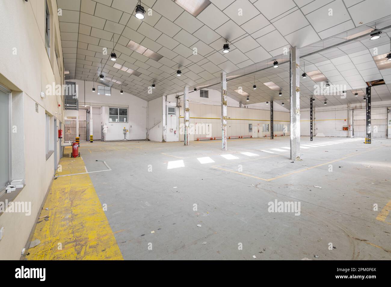 Parking garage with lights, light-colored walls, metal beams and ...