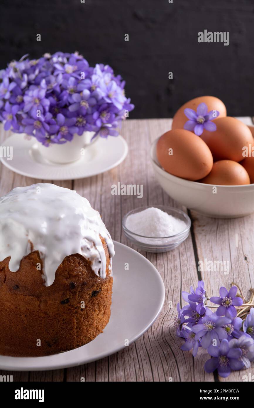photo of Easter sponge cake, eggs and flowers on the table Stock Photo ...