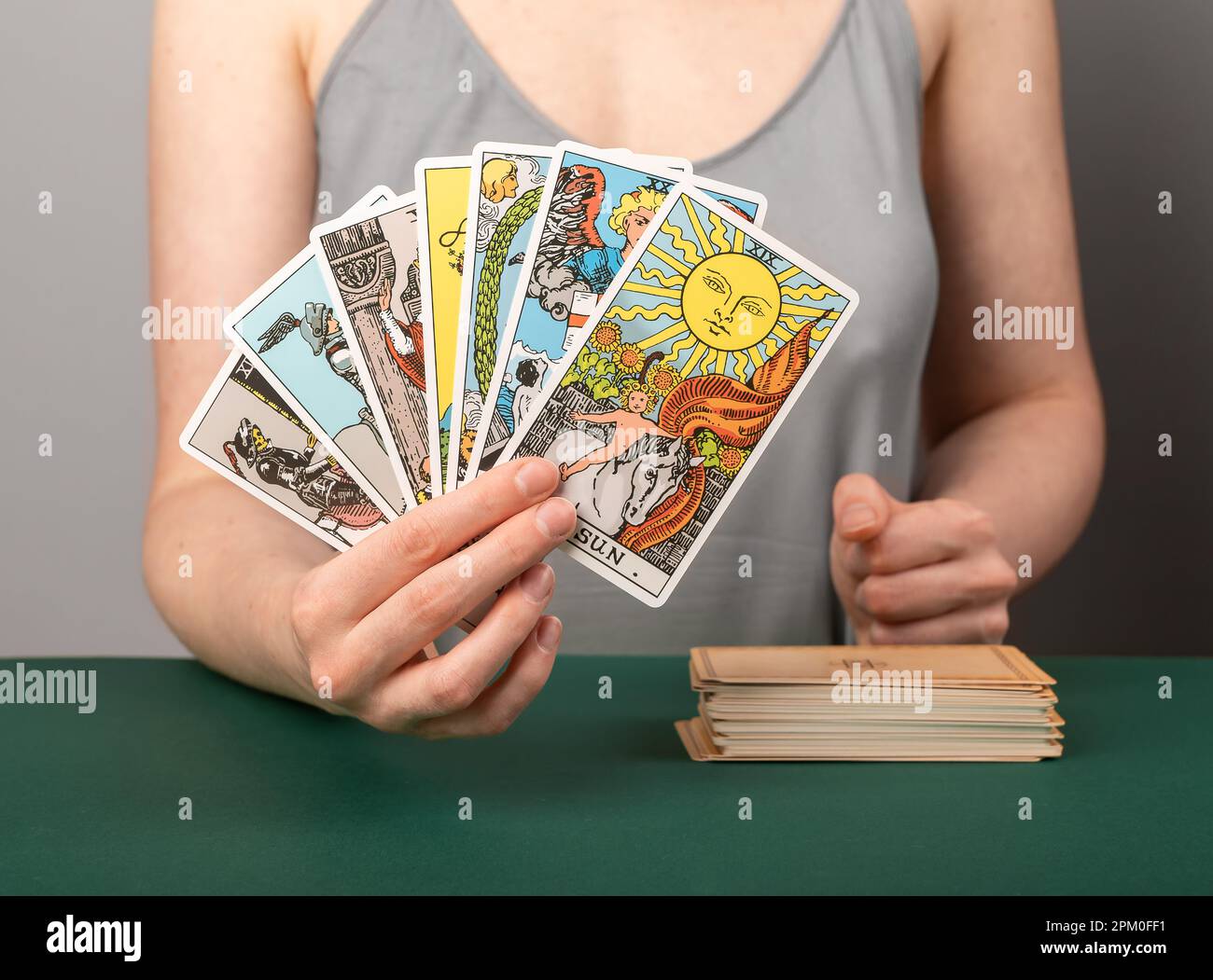 Lodz, Poland April 07 2023 Fortune teller showing tarot cards, arcanas in hand, reading, telling ...