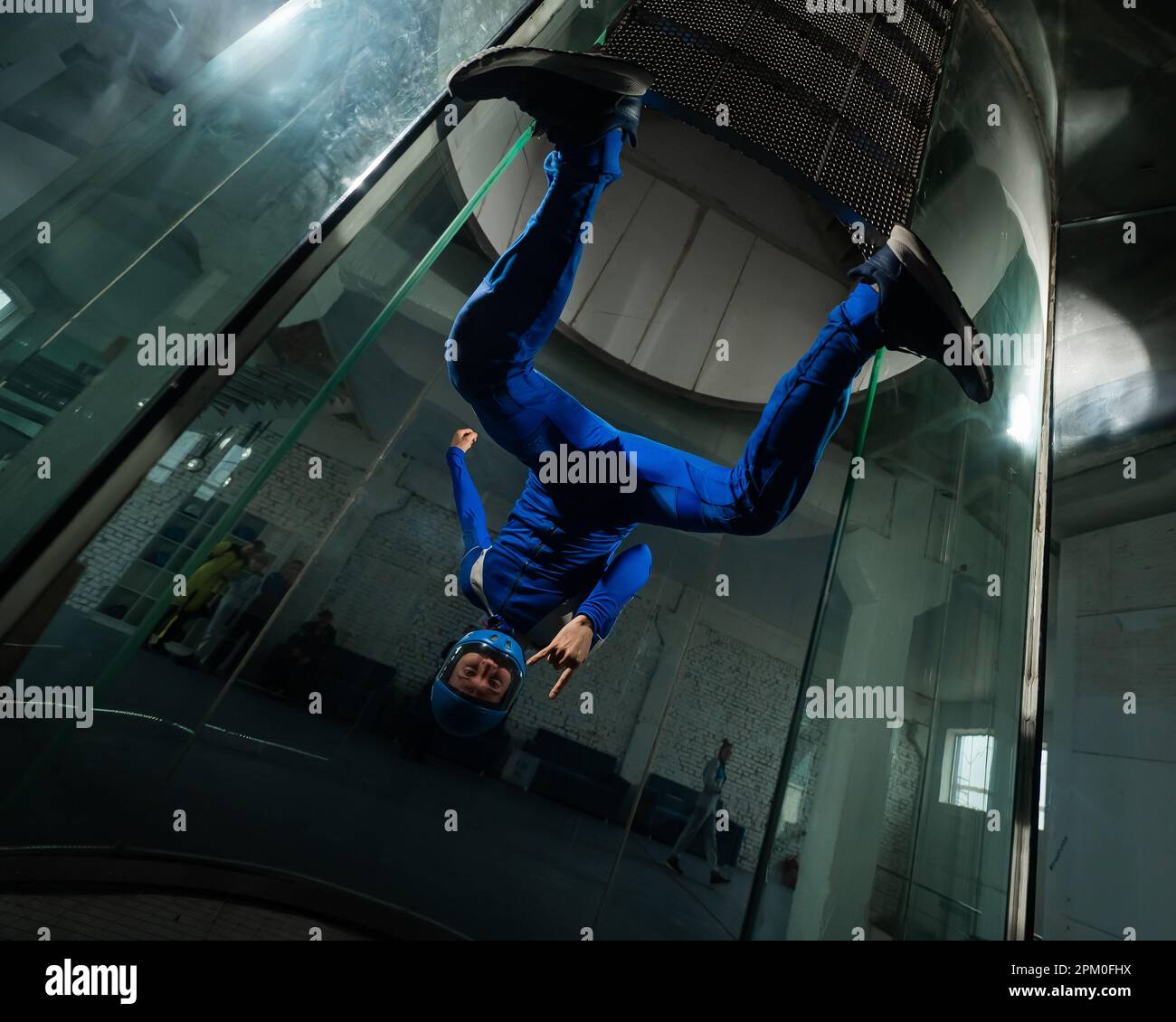 A man in overalls and a protective helmet enjoys flying in a wind ...