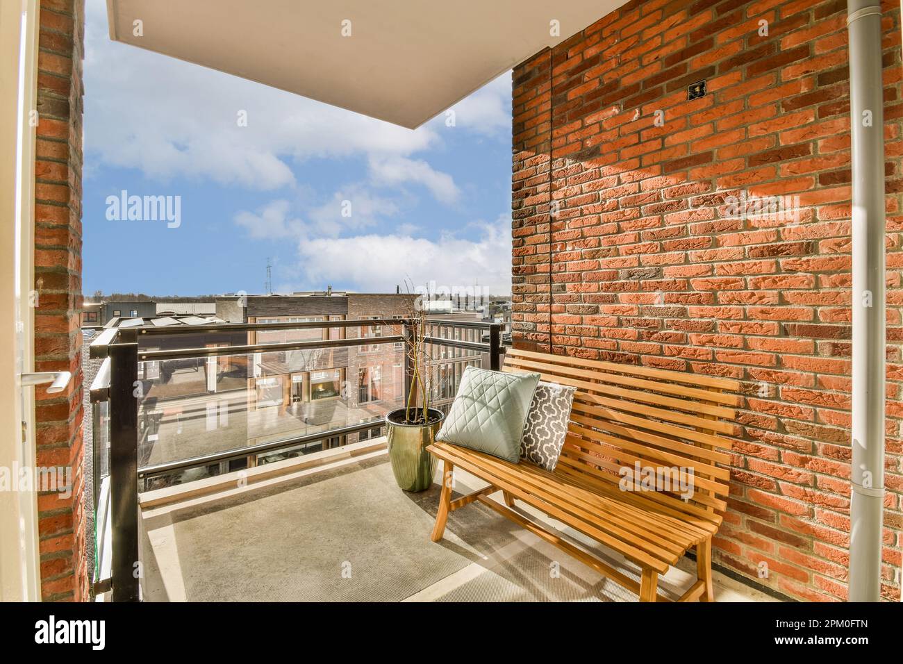 a balcony with a wooden bench on the left side and a blue sky in the ...
