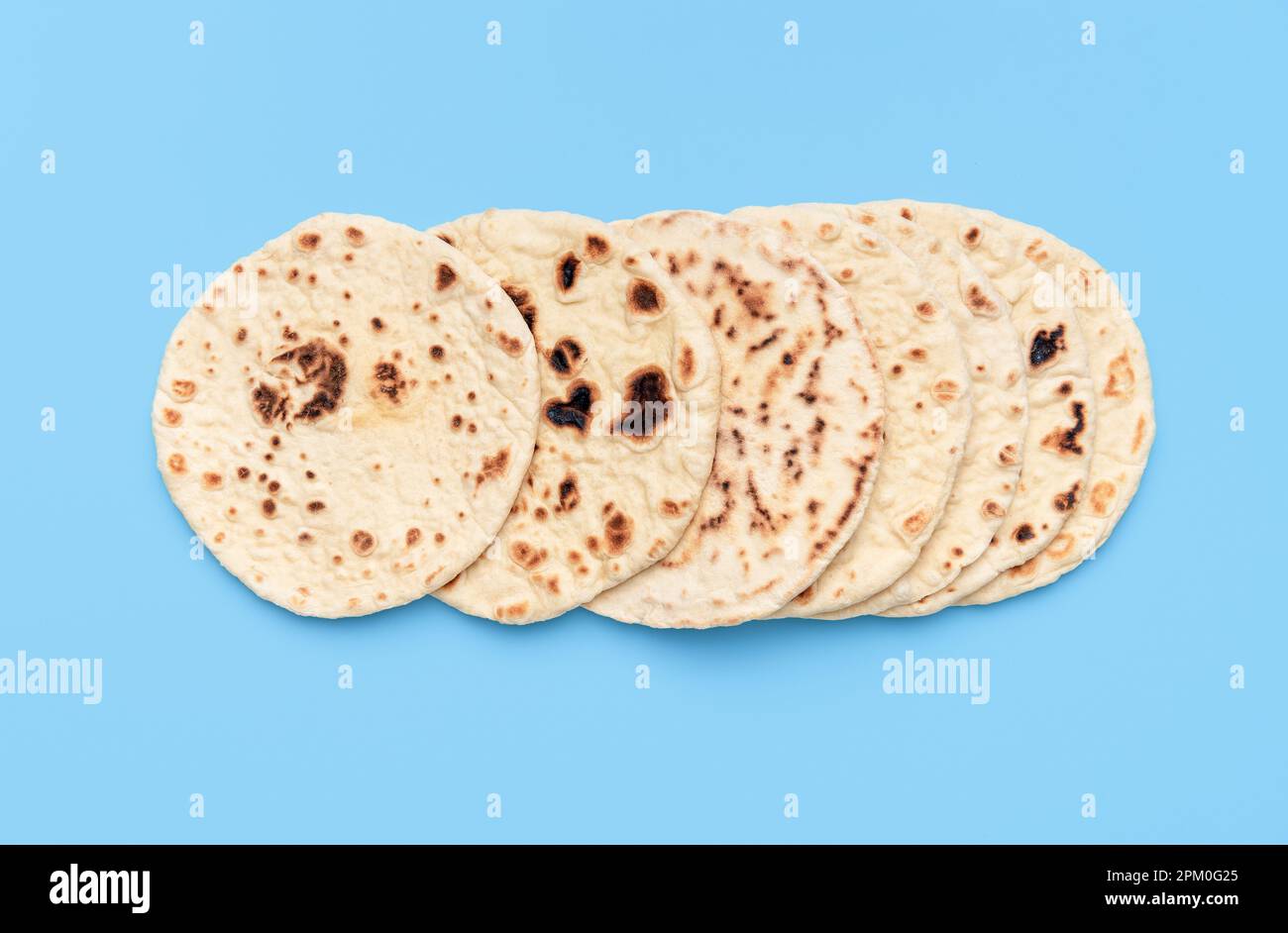 Above view with several naan breads, minimalist on a blue table ...