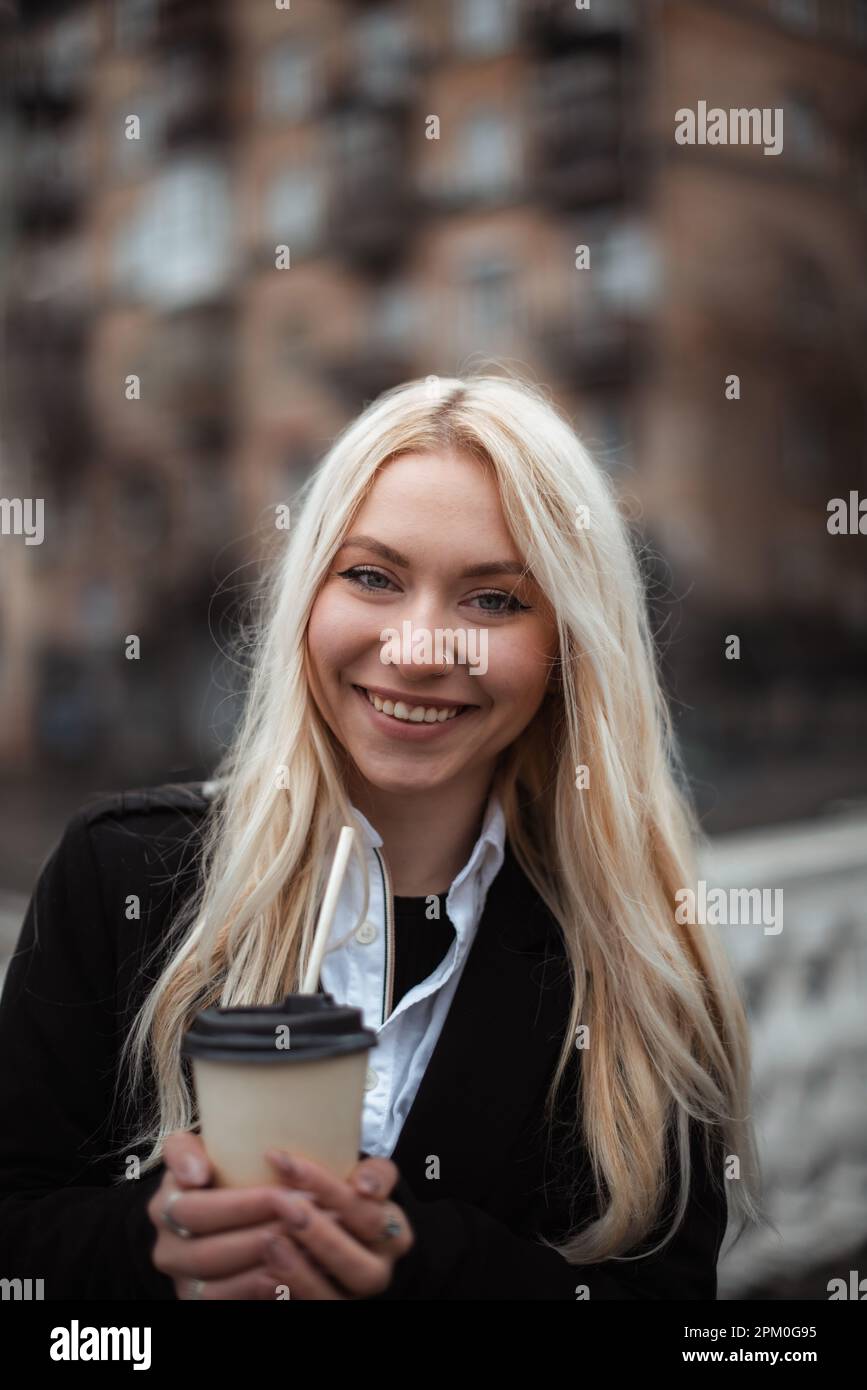 happy girl student drinks coffee before studying on city building ...