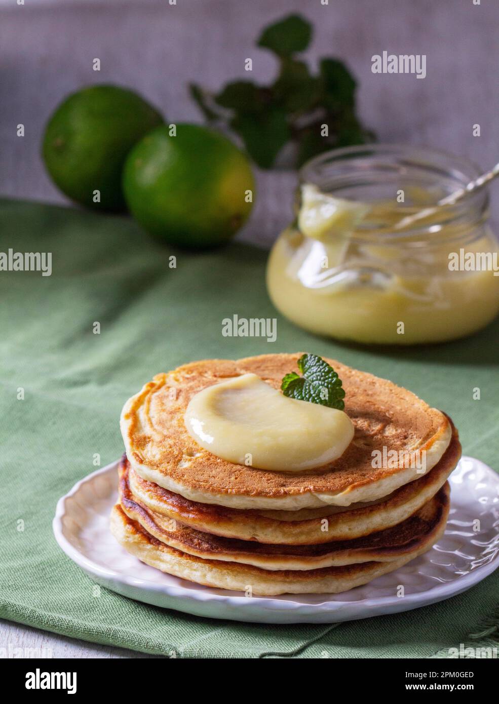 Whole grain flour fritters served with lime curd on a light background ...