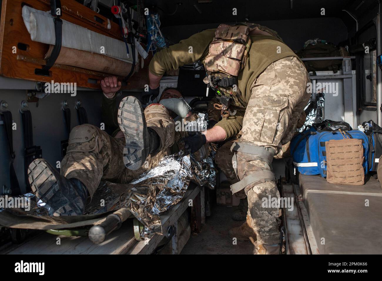 Military medics give first aid to a soldier wounded in a battle in an ...