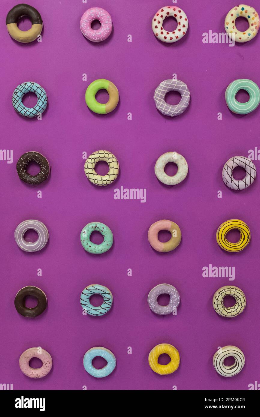 Round donuts food with different decoration on a solid purple pink ...