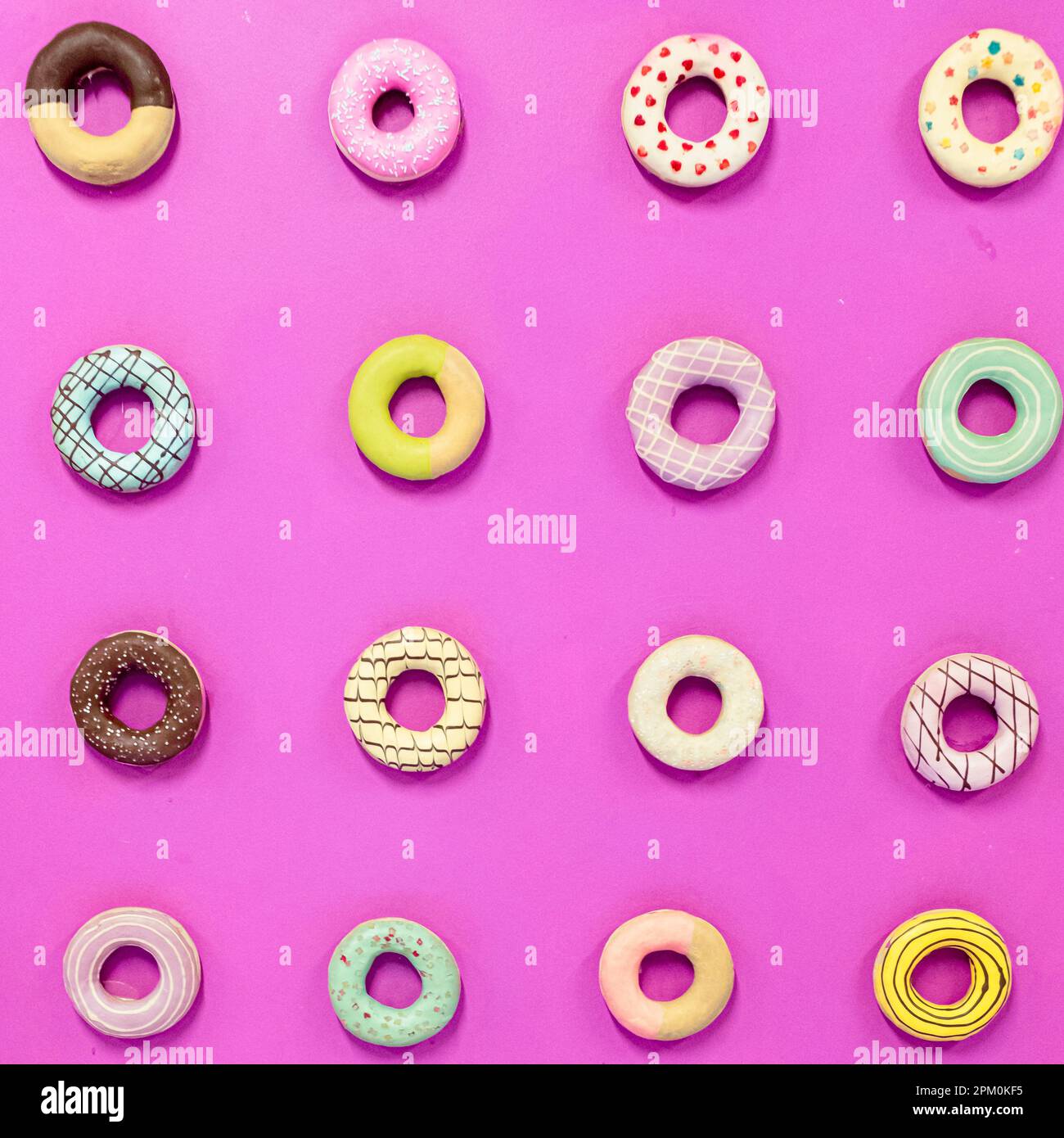 Round donuts food with different decoration on a solid purple pink ...
