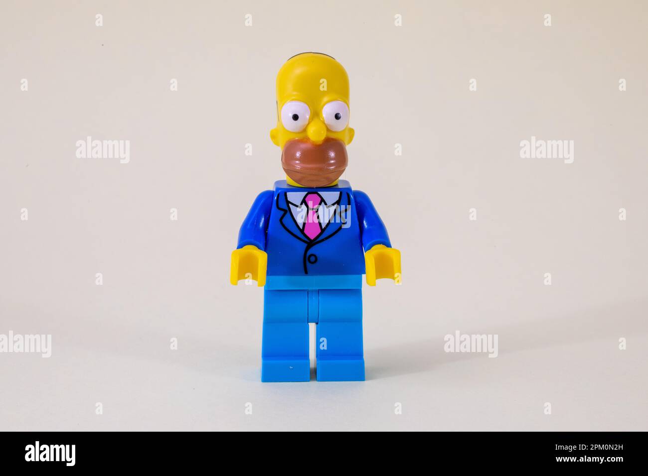 A Lego man wearing a suit and tie stands confidently, looking ahead ...
