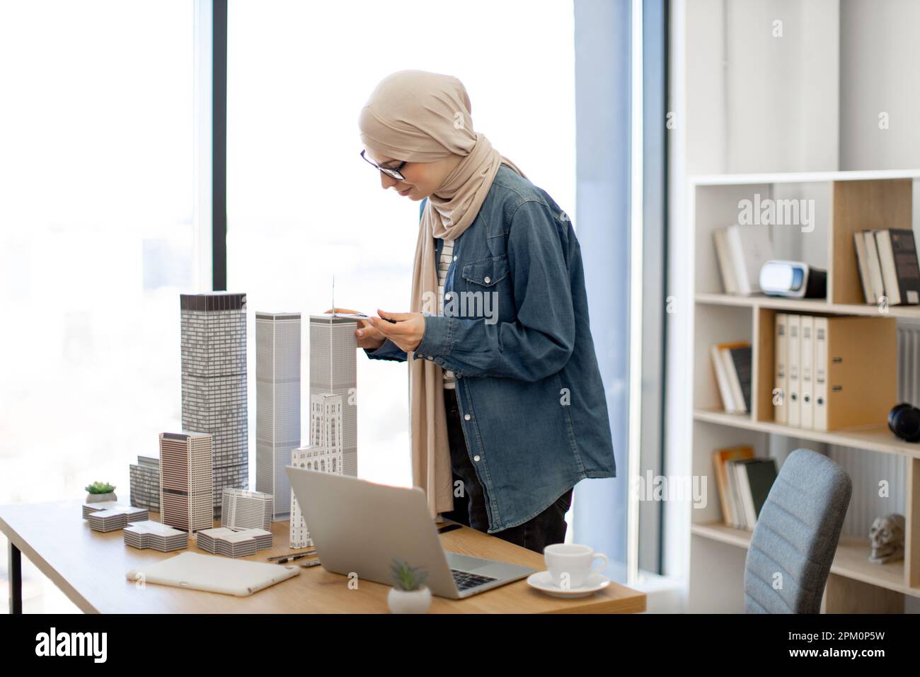 Happy muslim lady wearing beige hijab using drafting compass while ...
