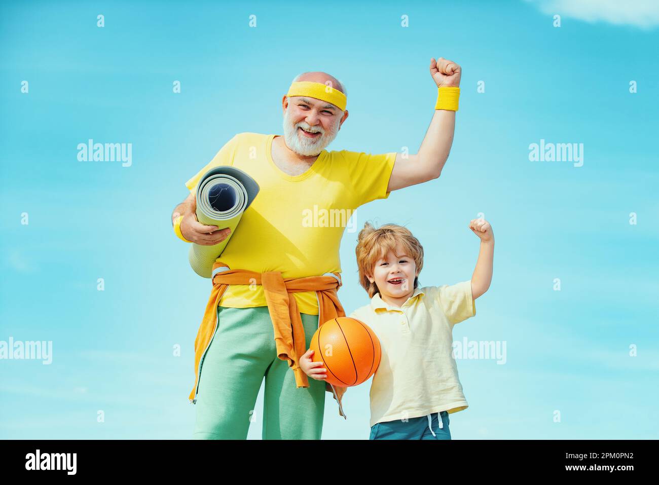 Senior man and child exercising on blue sky. Sports for kids. Sportsman ...
