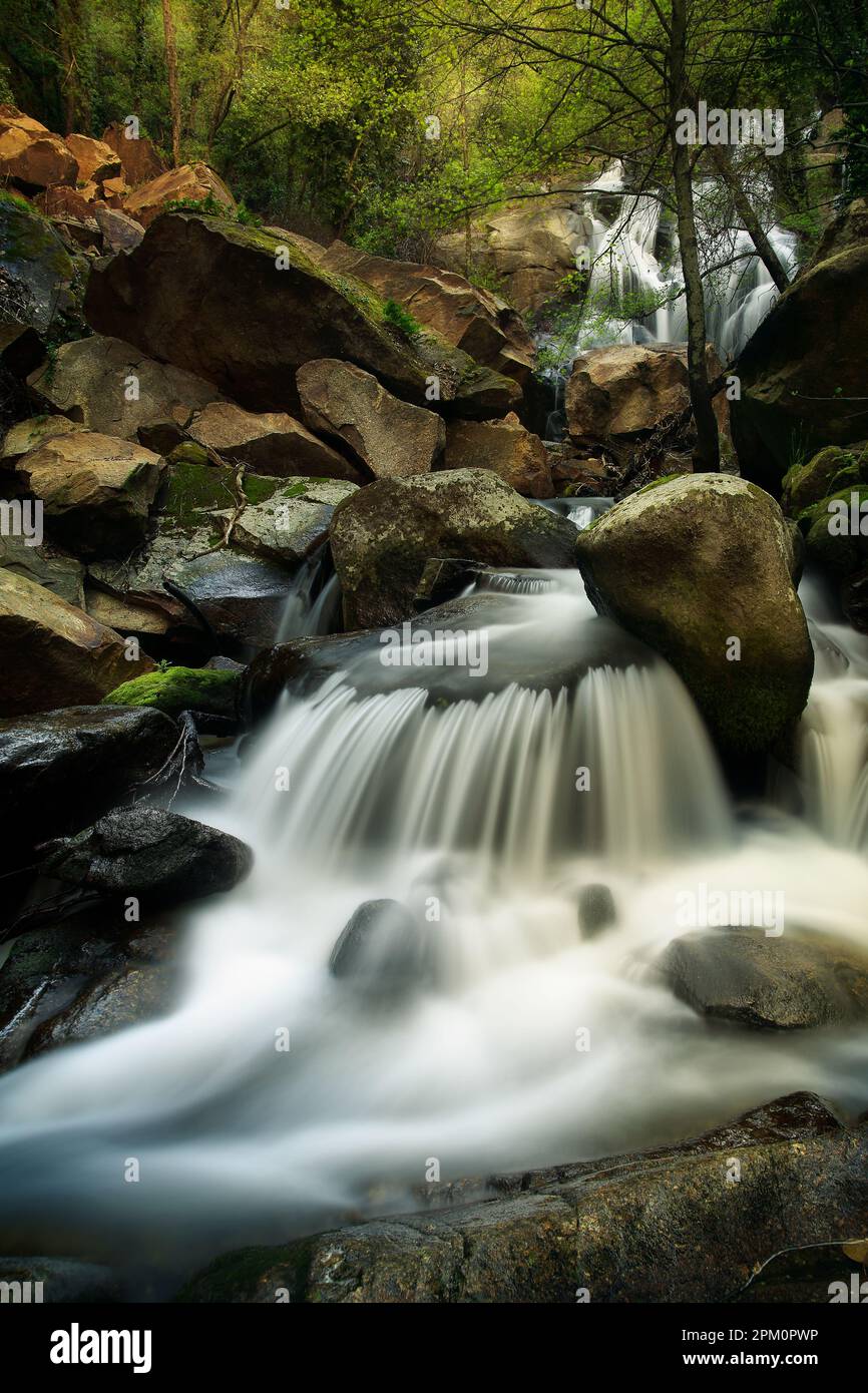 passage of a river between round boulders causing large waterfalls ...