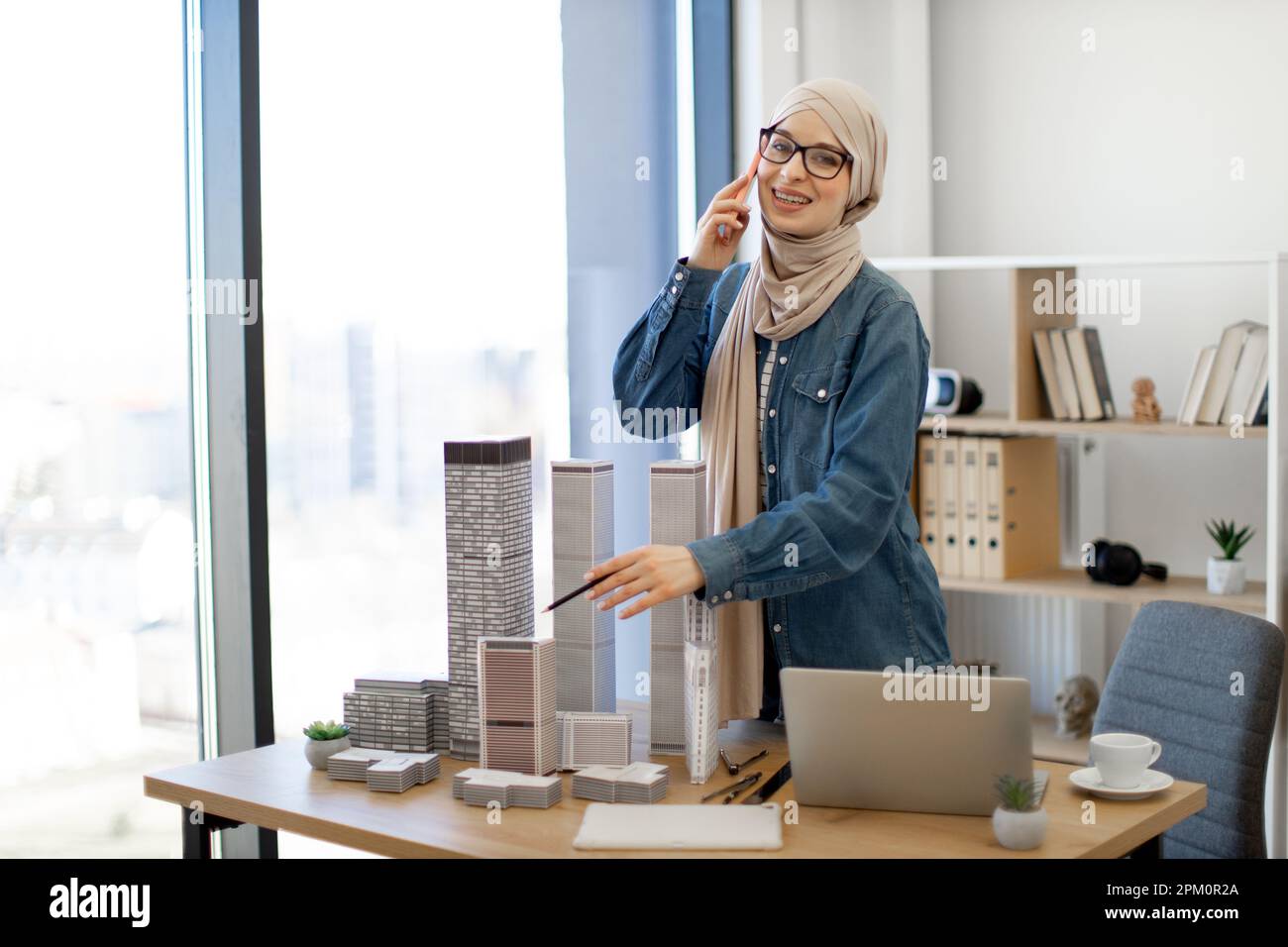 Happy muslim adult wearing hijab and casual wear speaking on mobile ...