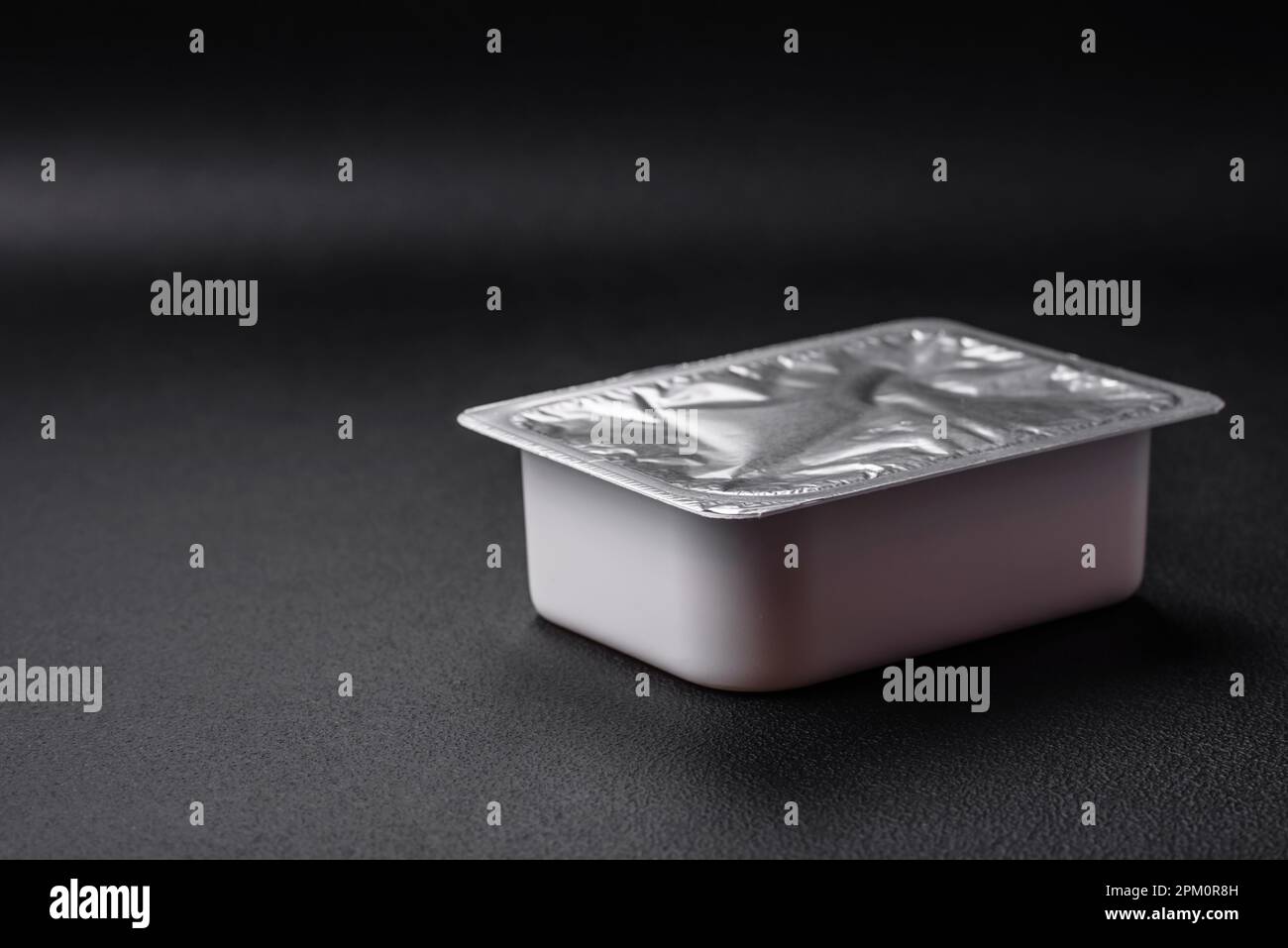 Rectangular plastic box with yogurt or cheese hermetically sealed with ...