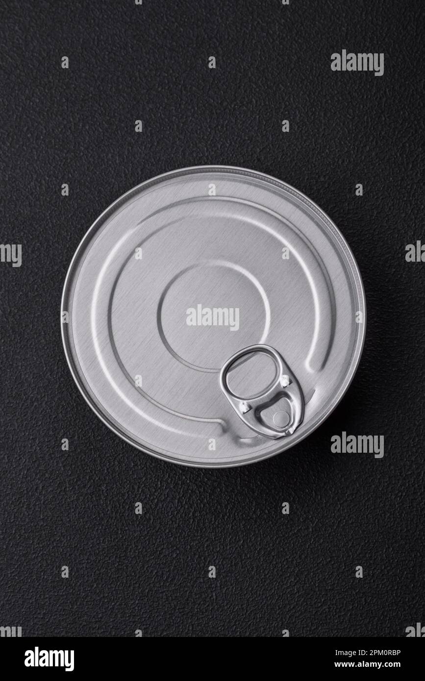 Tin metal can with canned food round shape with a key on a dark ...