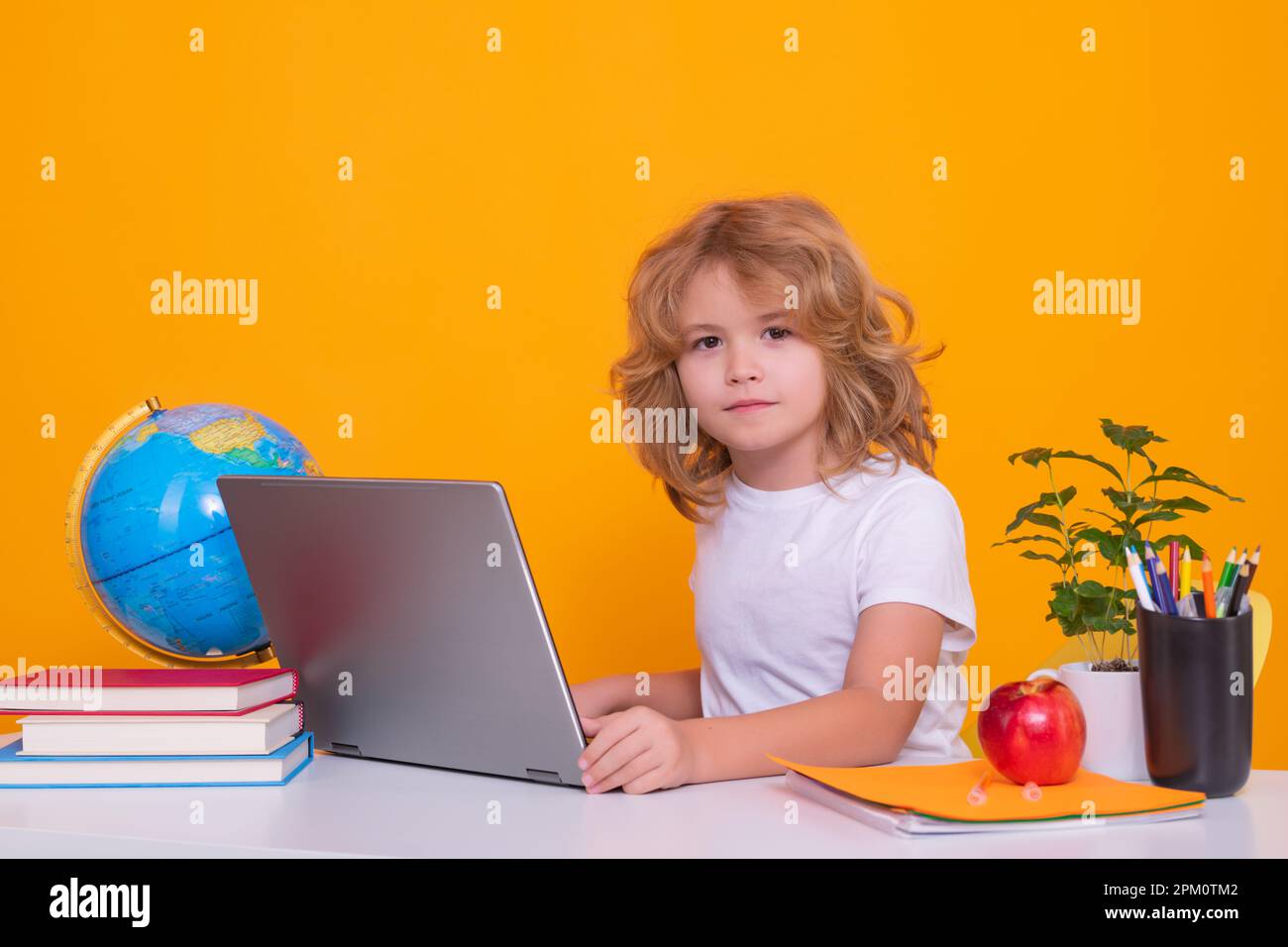 School child using laptop computer. School child studying in classroom ...