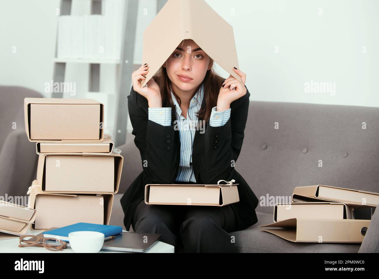 Sad busy secretary with many folders of documents, stressed overworked ...