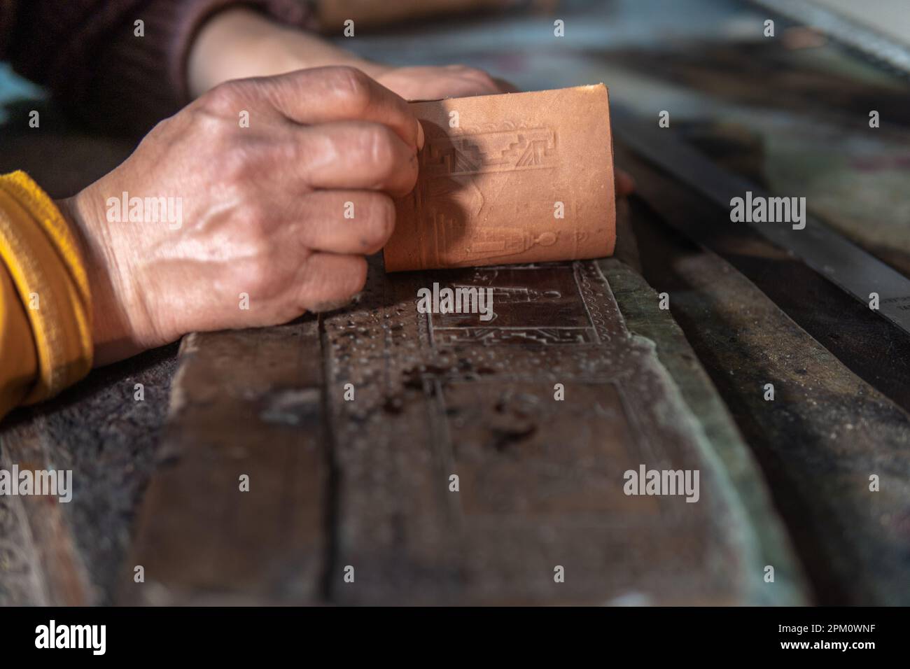Hands of an artisan embossing in leather Stock Photo - Alamy