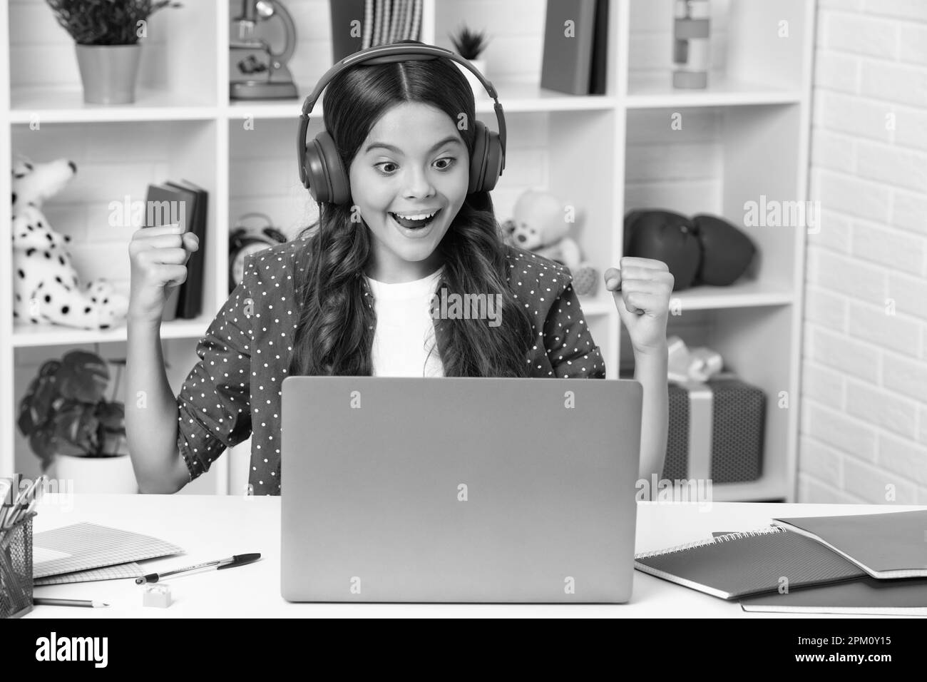 School girl student sitting at the table, using laptop when studying ...