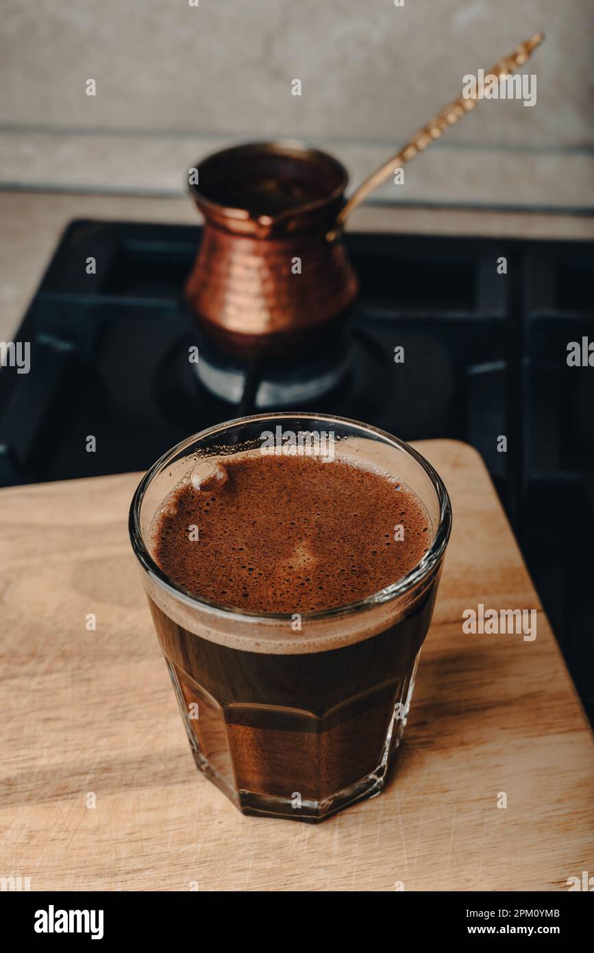 Glass of Turkish Coffee Brewed in Copper Cezve on Stove Stock Photo - Alamy