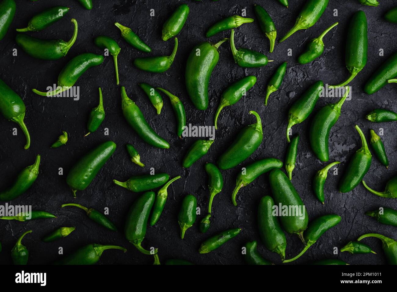 Background of Ripe Green Jalapeno Peppers on Dark Concrete Surface ...