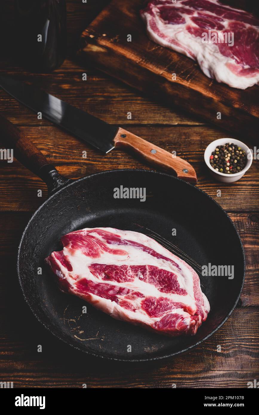 Raw pork neck steak in cast iron skillet Stock Photo - Alamy