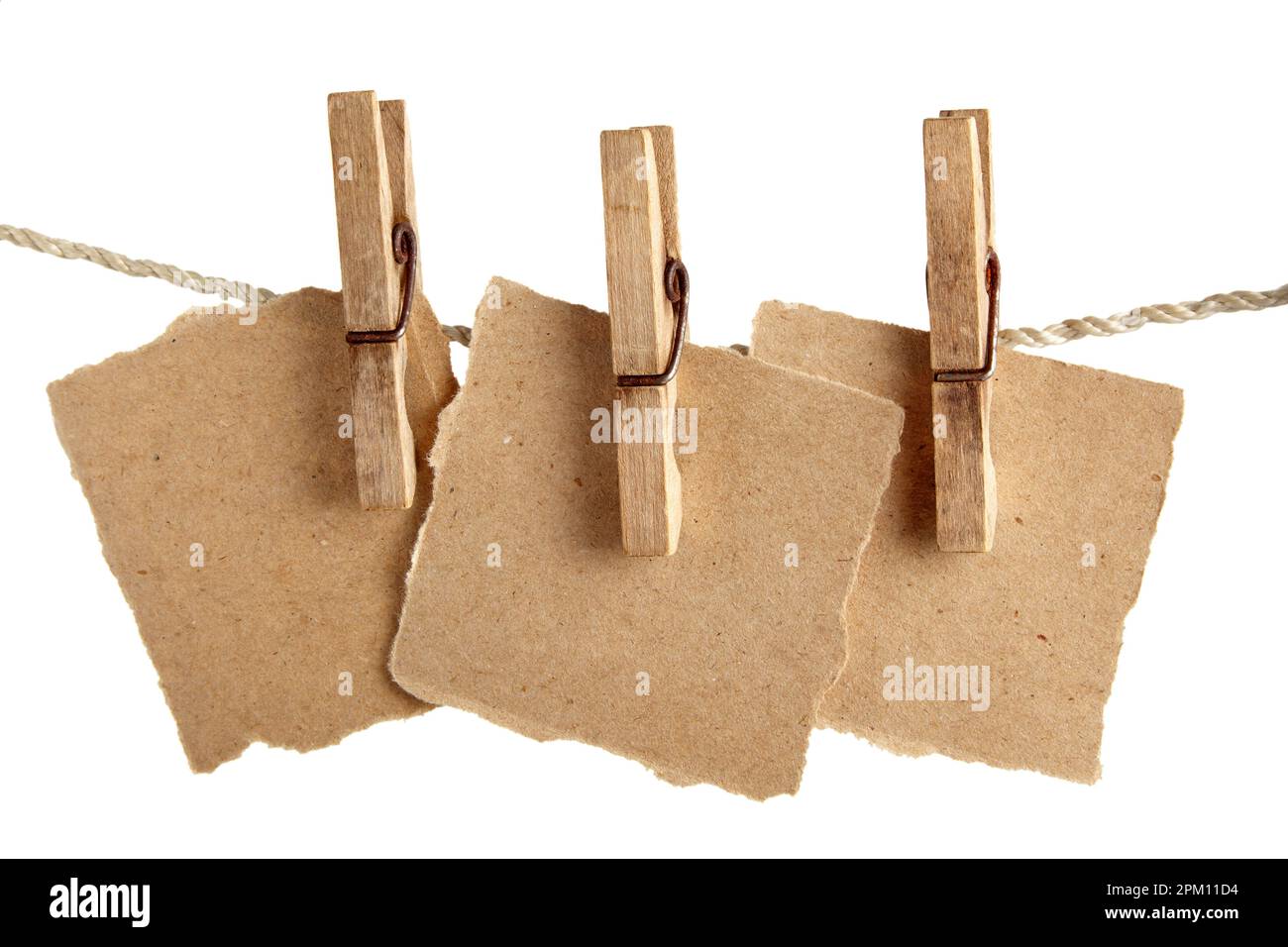 Craft note paper pinned with a vintage clothespin on a rope on a white ...