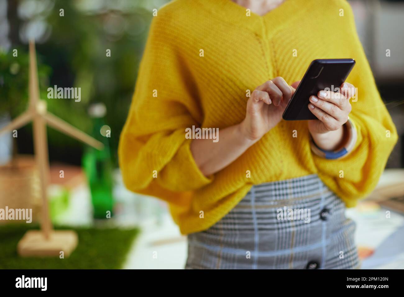 Closeup on small business owner woman in yellow sweater in the green ...